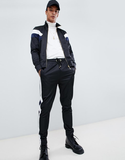 Criminal Damage tracksuit in black with blue side stripe | ASOS