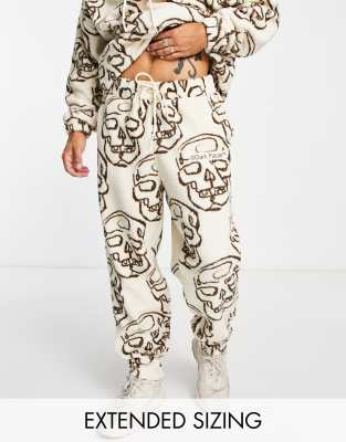 ASOS Dark Future relaxed trackies in teddy borg with all over skull print in ecru (part of a set ...