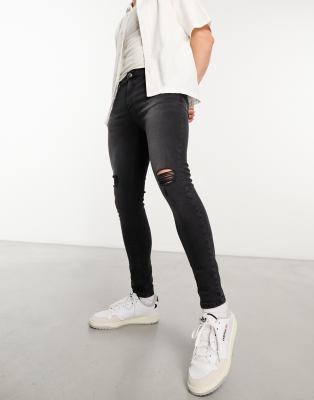 ASOS DESIGN spray on jeans with power stretch knee rips in washed black ...