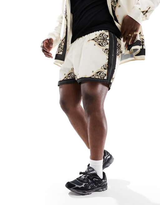 ASOS DESIGN swim shorts in short length with border print in stone ...