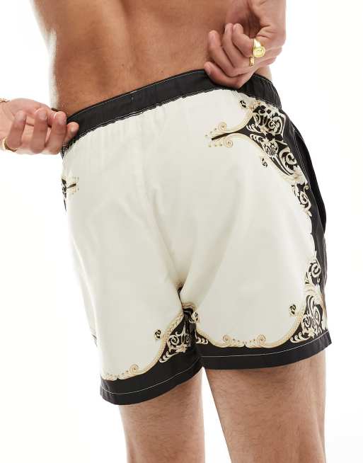 ASOS DESIGN swim shorts in short length with border print in stone ...