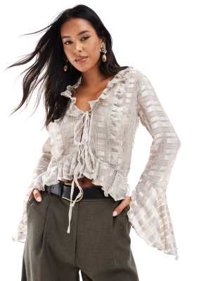 Blusa color visón a rayas a tono con lazada delantera y volantes de ...