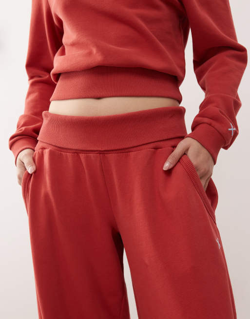 COLLUSION low rise trackies with fold over waistband in washed red ...