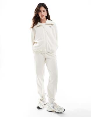 New Balance - Tuta sportiva tecnica in pile beige con zip | ASOS