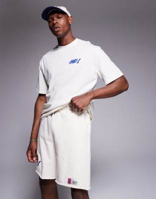 Pantalones cortos color crema extragrande con detalle de logo de punto ...