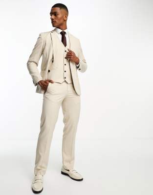 Pantalones de traje color crema elásticos de corte slim de tejido ...