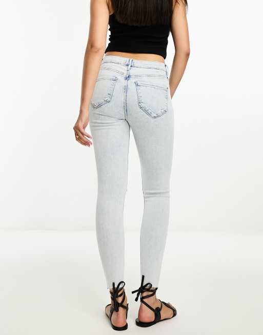 River Island Molly mid rise skinny jeans with ripped knee in light blue wash