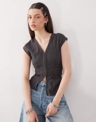 Top negro apagado con cuello de pico y detalle de corchetes de tejido ...