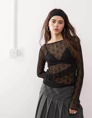 Top negro transparente de manga larga con detalle de la marca de encaje ...