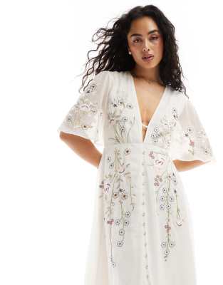 Vestido midi color crema con falda de corte amplio y bordados de ...